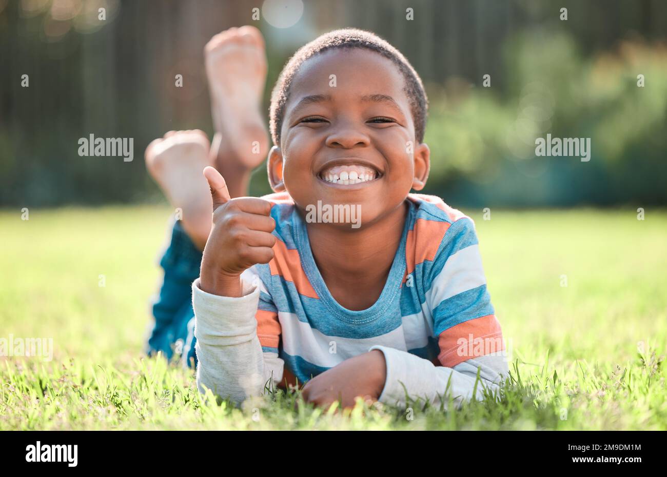 I like you, too. a young boy lying on the grass outside Stock Photo - Alamy