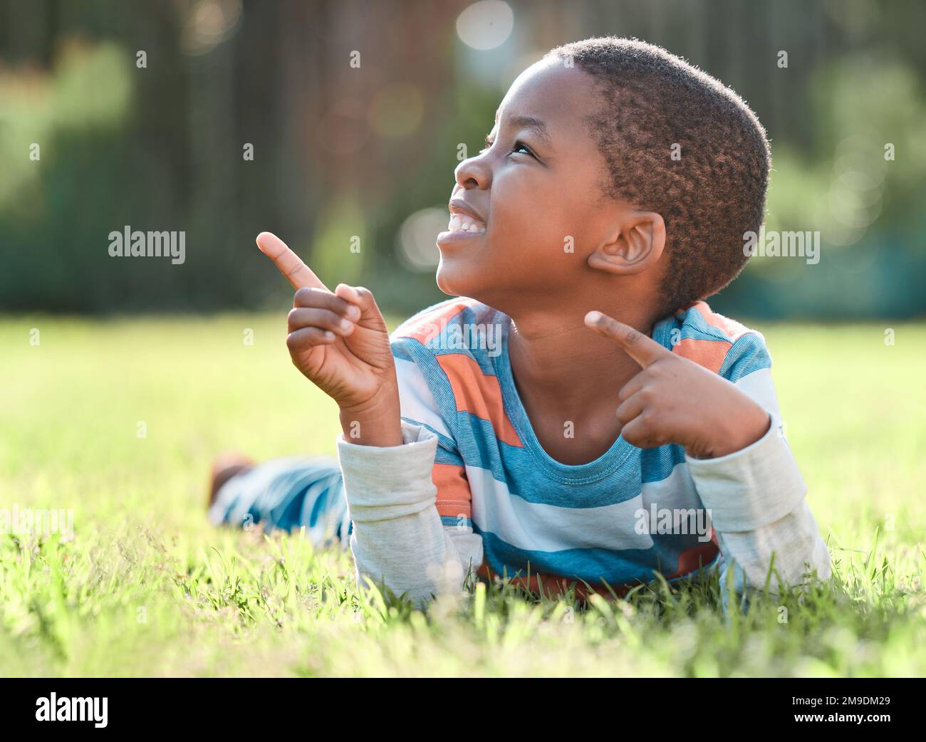 Thats so cool. a young boy lying on the grass outside Stock Photo - Alamy