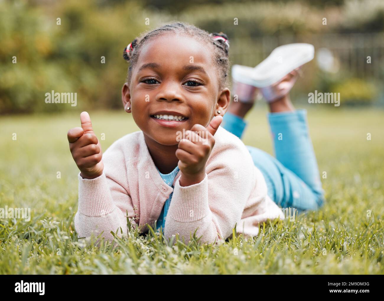 Itll all be alright. a little girl giving the thumbs up while relaxing ...