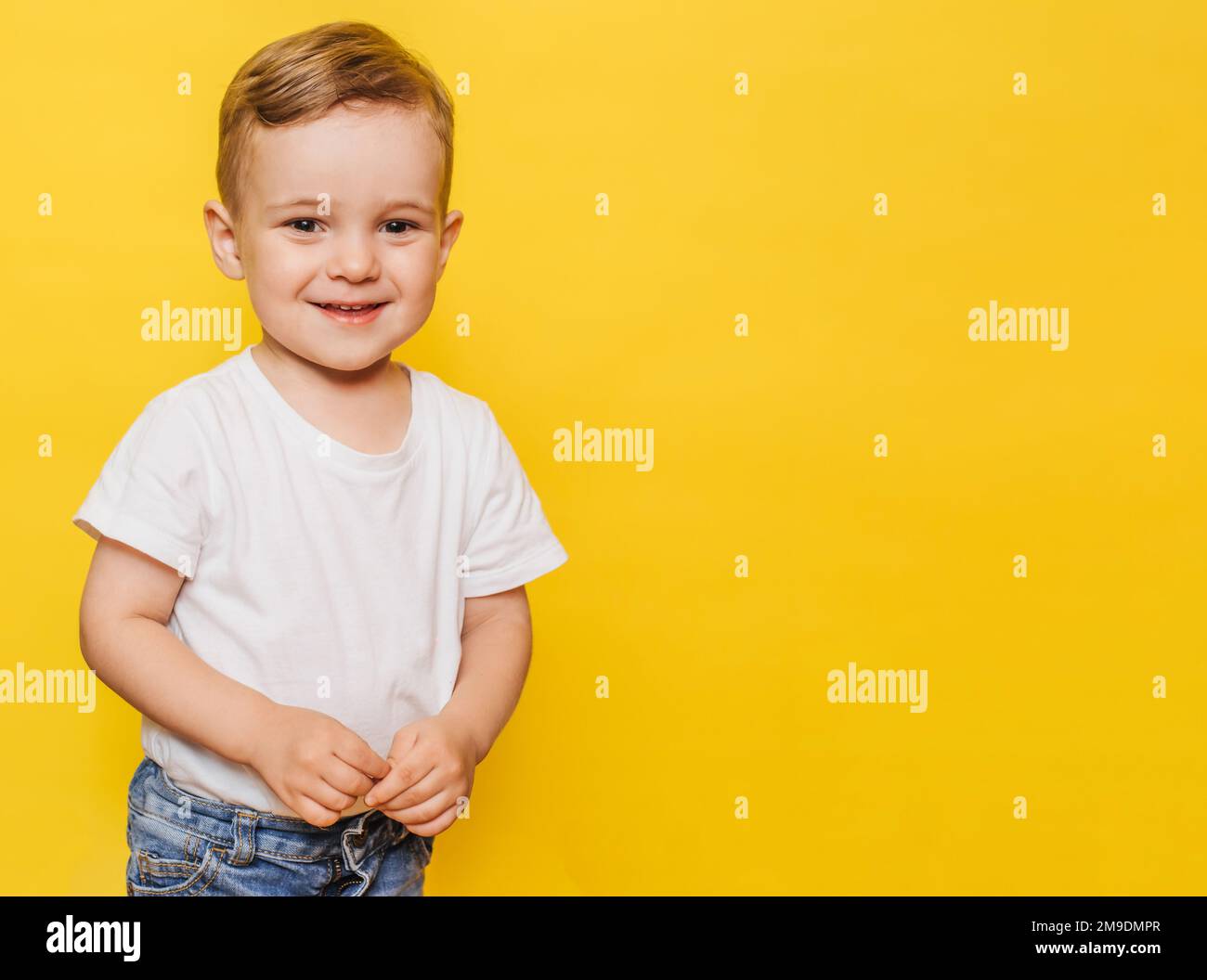 Portrait of a cute laughing little boy yellow background. Copy space ...