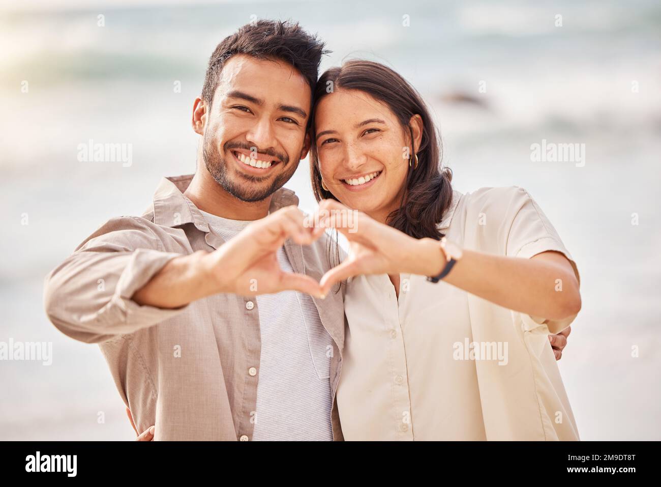 She completes me. a young couple making a heart gesture with their ...