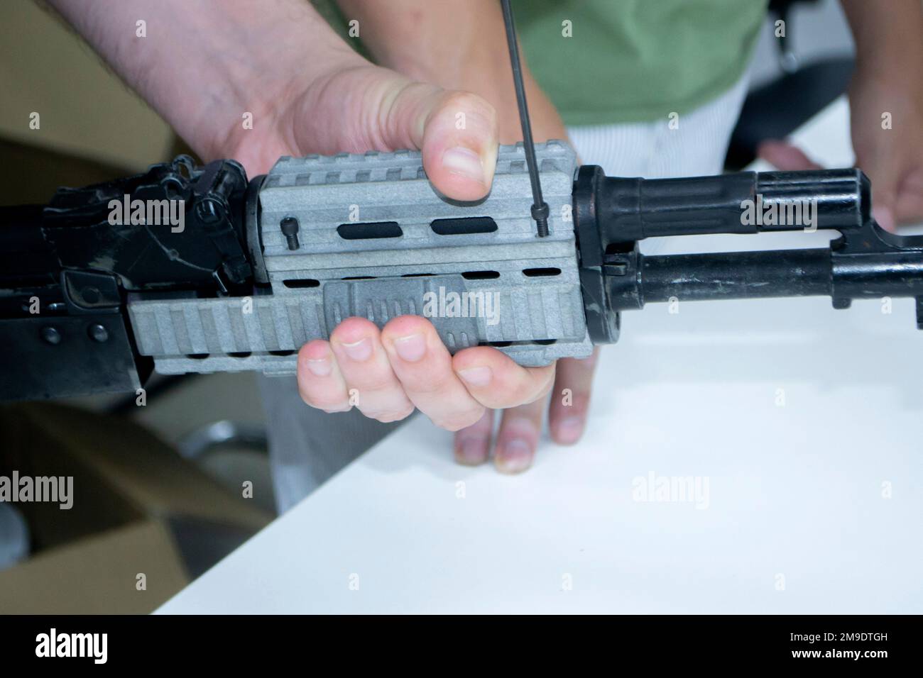 3D printed weapon parts. Man assembles weapon rifle, some parts printed ...