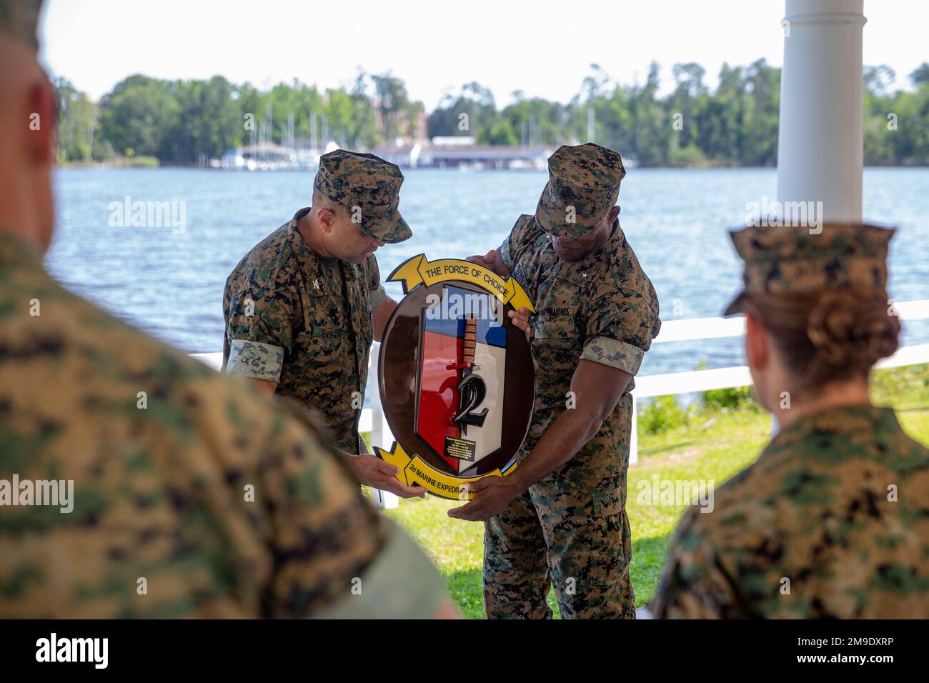 U.S. Marine Corps Col. David Everly presents a commemorative plaque to ...