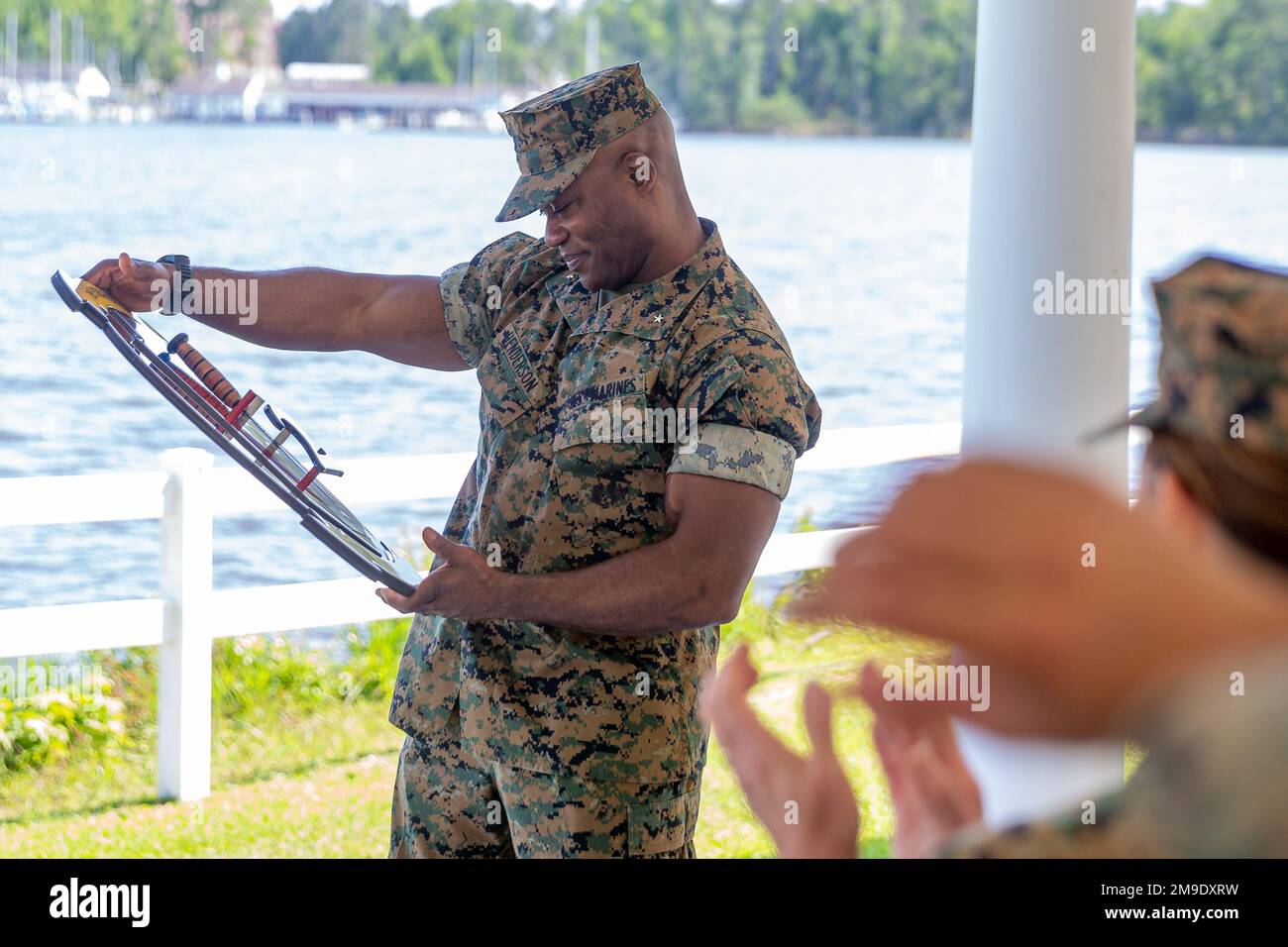 U.S. Marine Corps Col. David Everly presents a commemorative plaque to ...