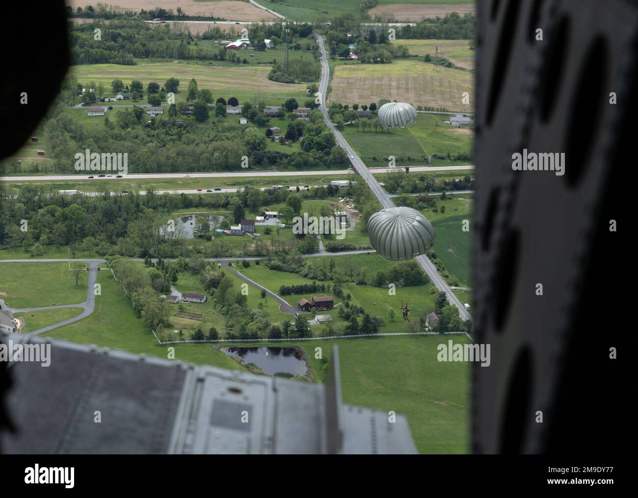 Service Members from the U.S. Air Force float away on their parachutes ...