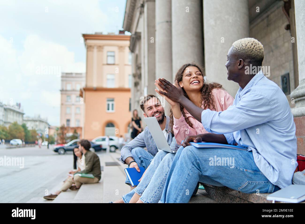 Happy students sitting on steps hi-res stock photography and images - Alamy