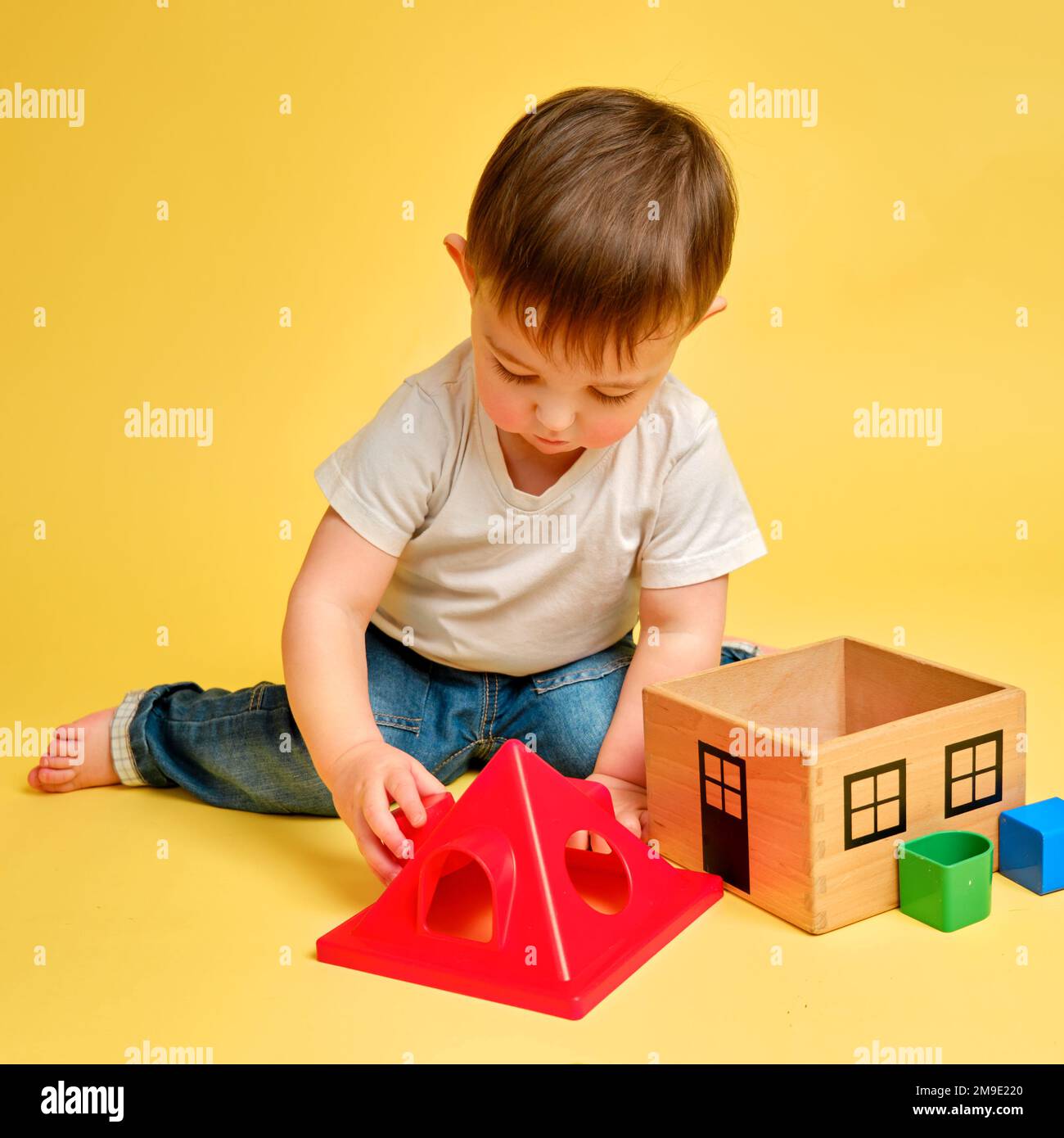 Toddler baby is playing sorter logic educational games with geometric ...