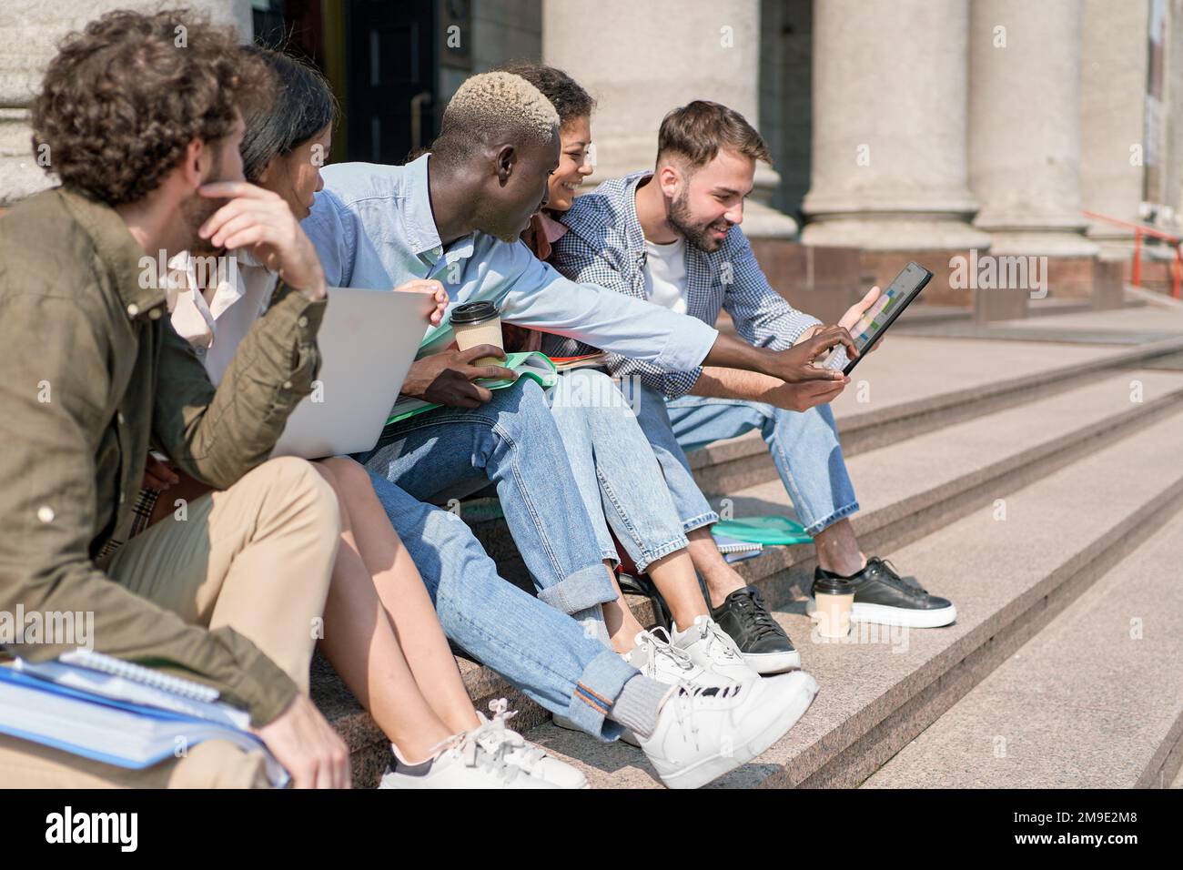 group of students discussing a group project sitting on the steps Stock ...