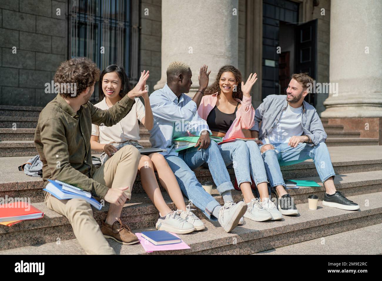 student friends giving each other a high five. education, youth ...