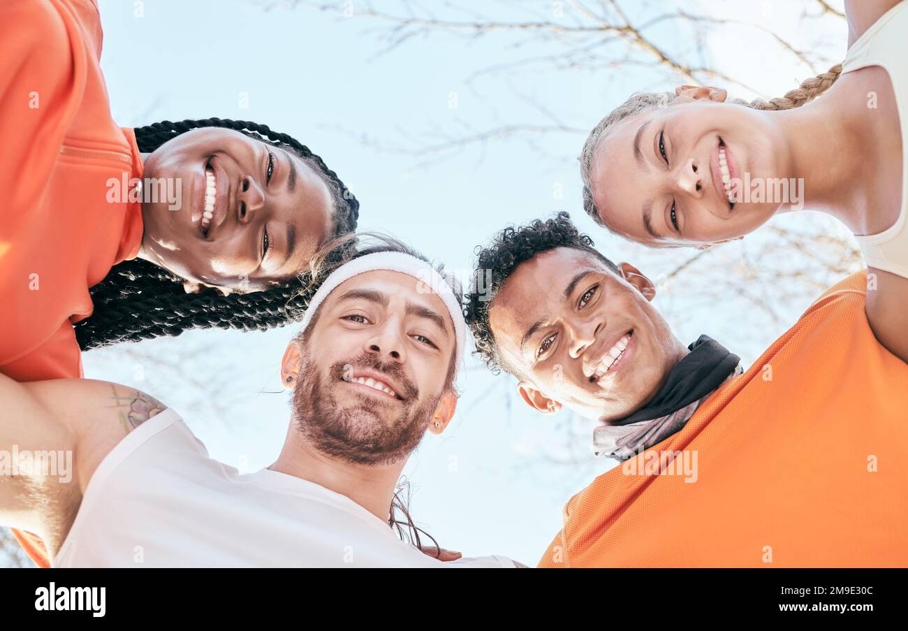 The only way from here is up. Low angle shot of a diverse group of friends standing huddled ...