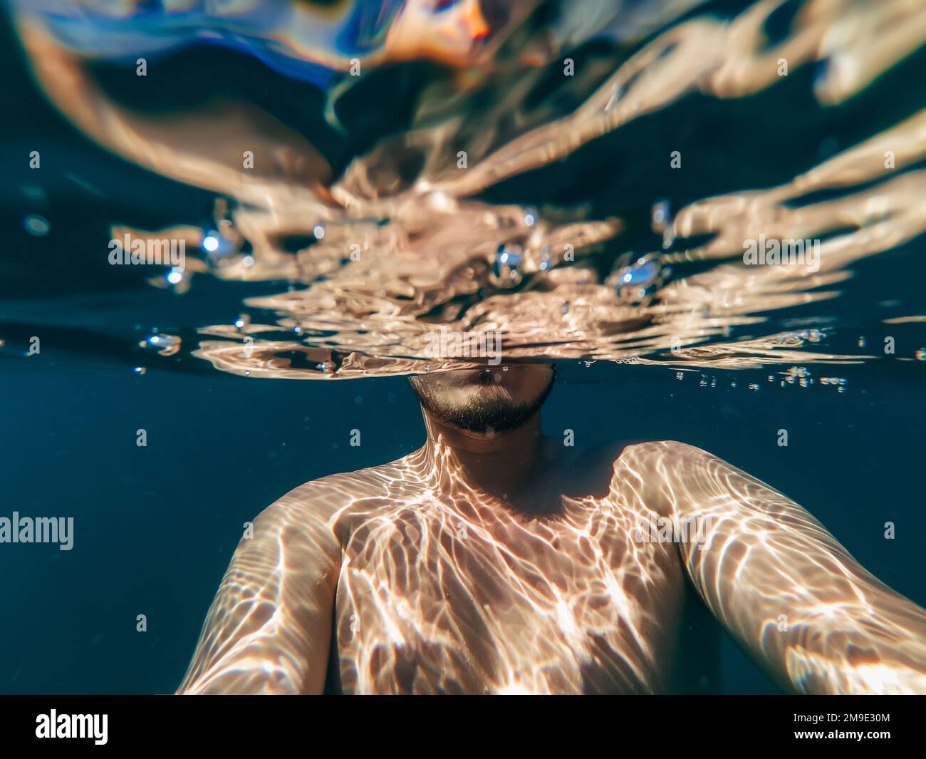 underwater photo of a man's body floating in the sea in blue water ...
