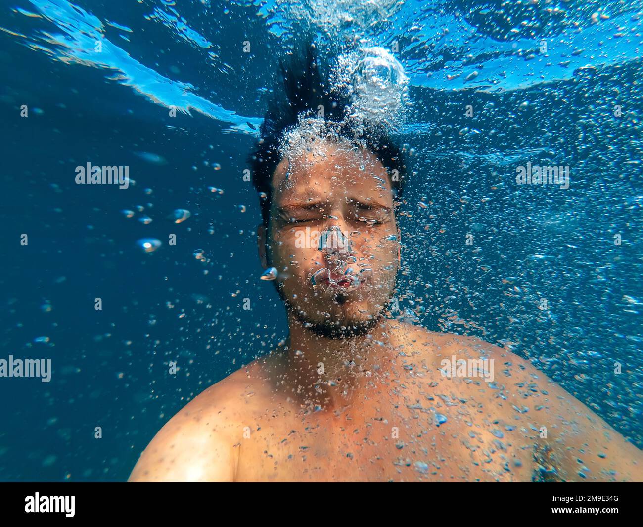 man under the water sinks to the bottom and releases bubbles of oxygen ...