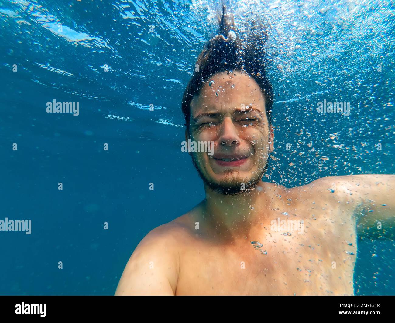 man under water, drowning with an expression of fear and horror on her ...