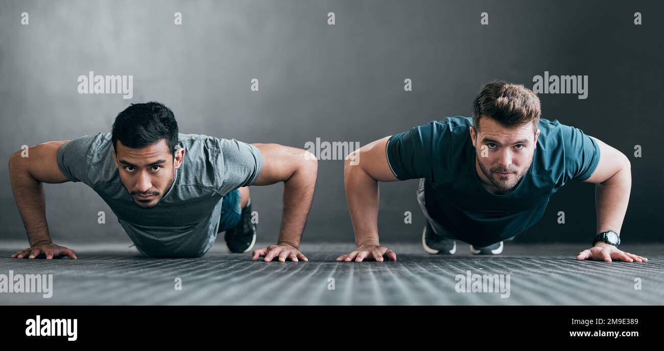 Working on their upper body. Full length portrait of two handsome young ...