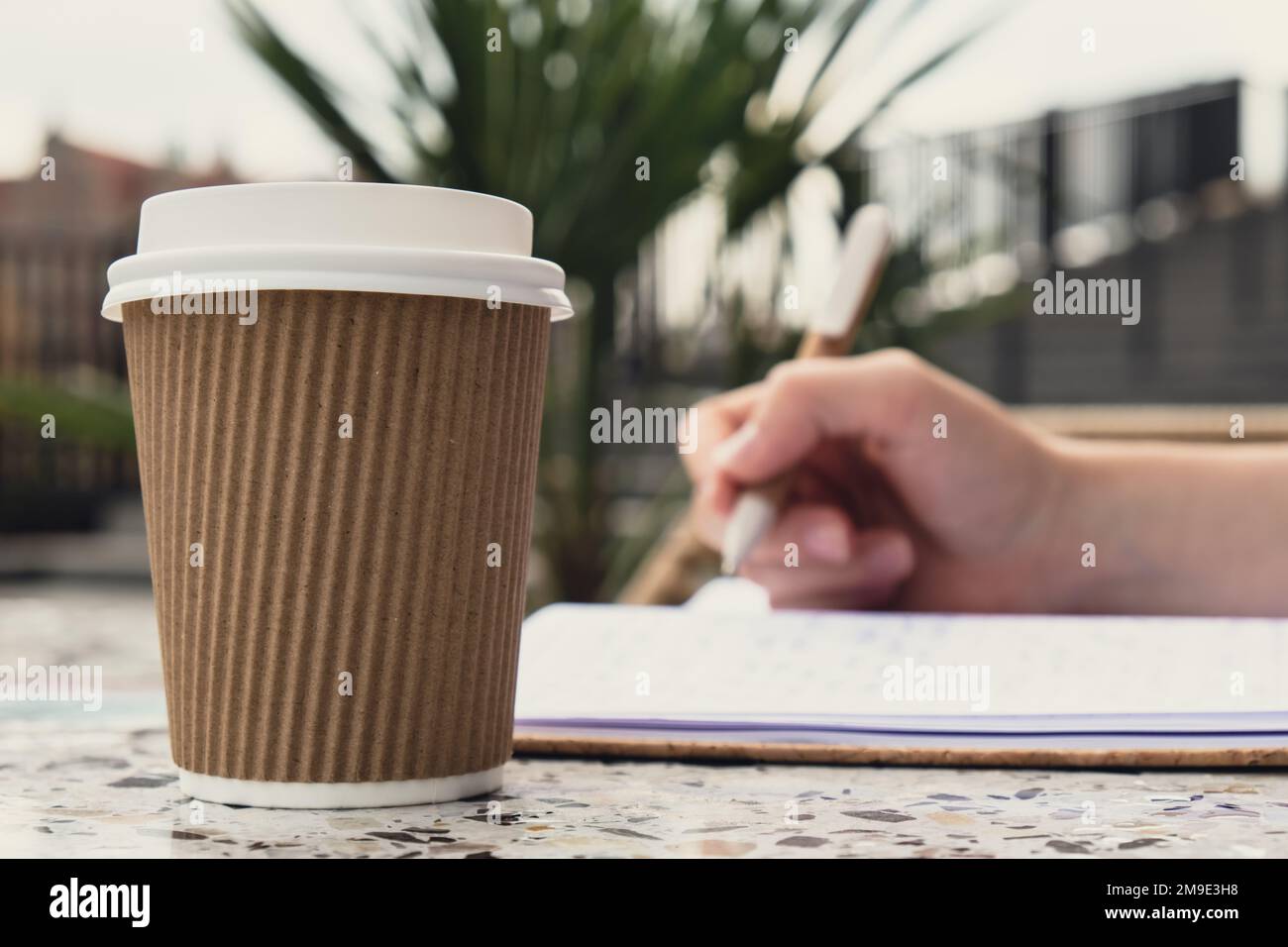 Unrecognizable Young woman study in beach resort. Drinking coffee from ...