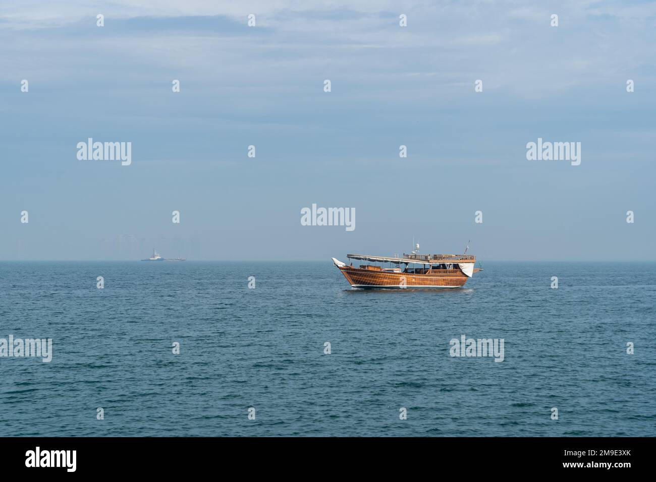A traditional dhow in Doha, Qatar with the city's modern skyline in the ...