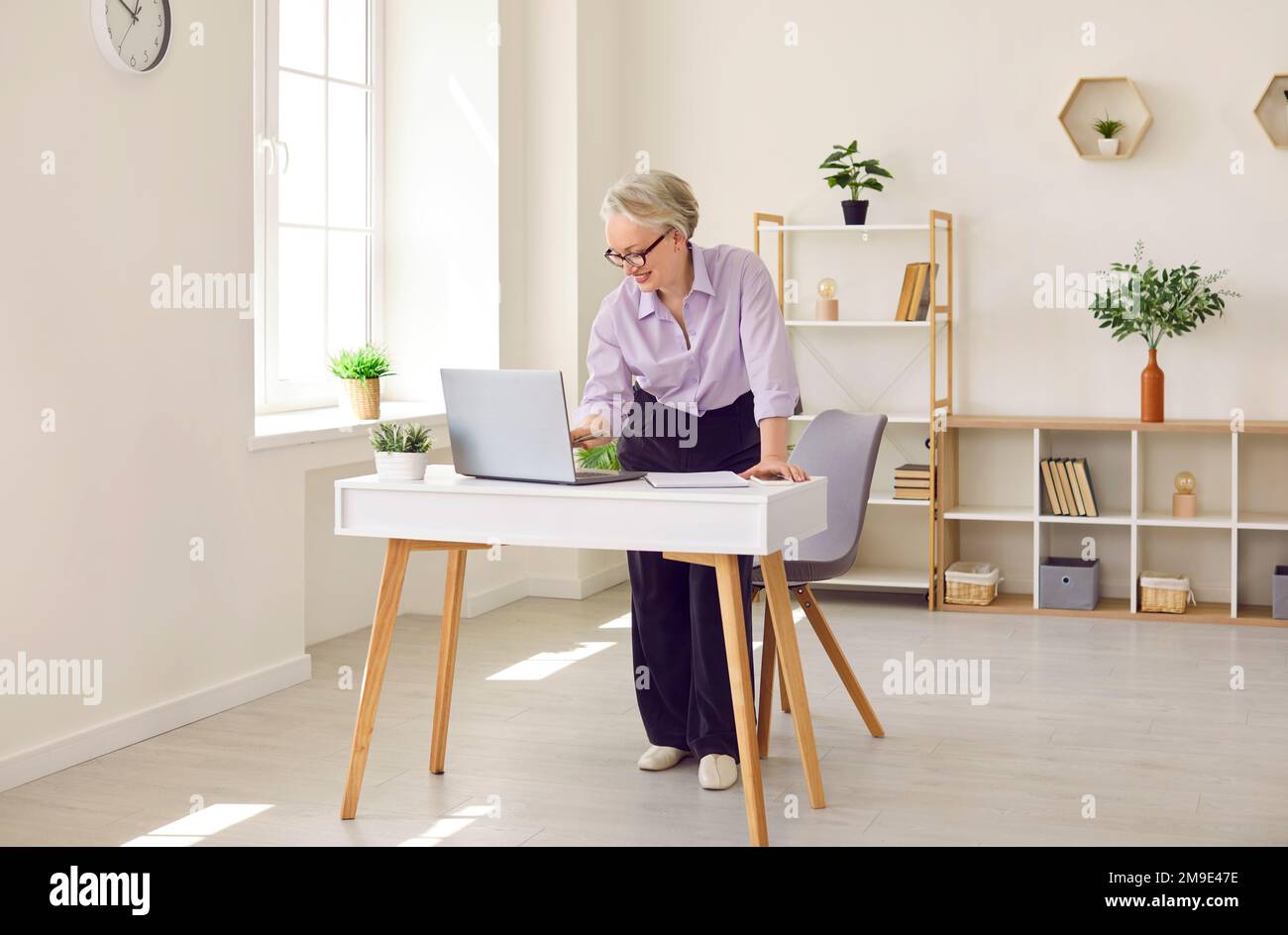 Happy businesswoman working on her laptop computer in a modern ...