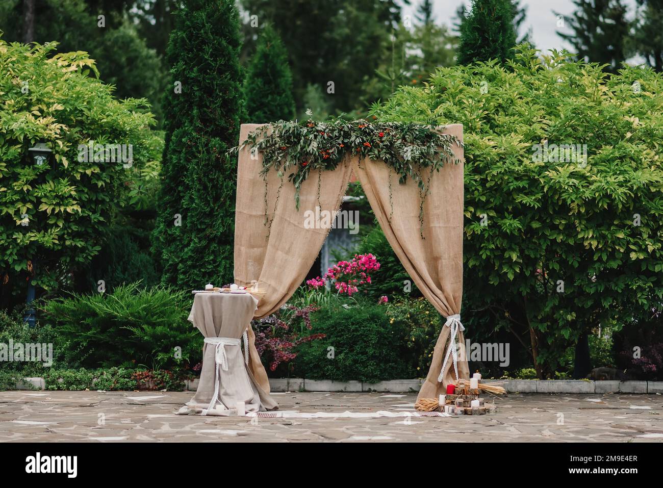 wedding arch decorated in rustic style with fabrics on the background ...