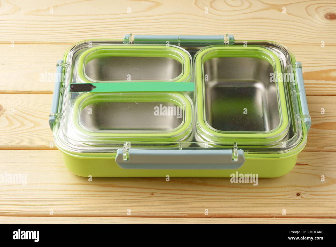 Metal lunch box with compartments on wooden background Stock Photo - Alamy