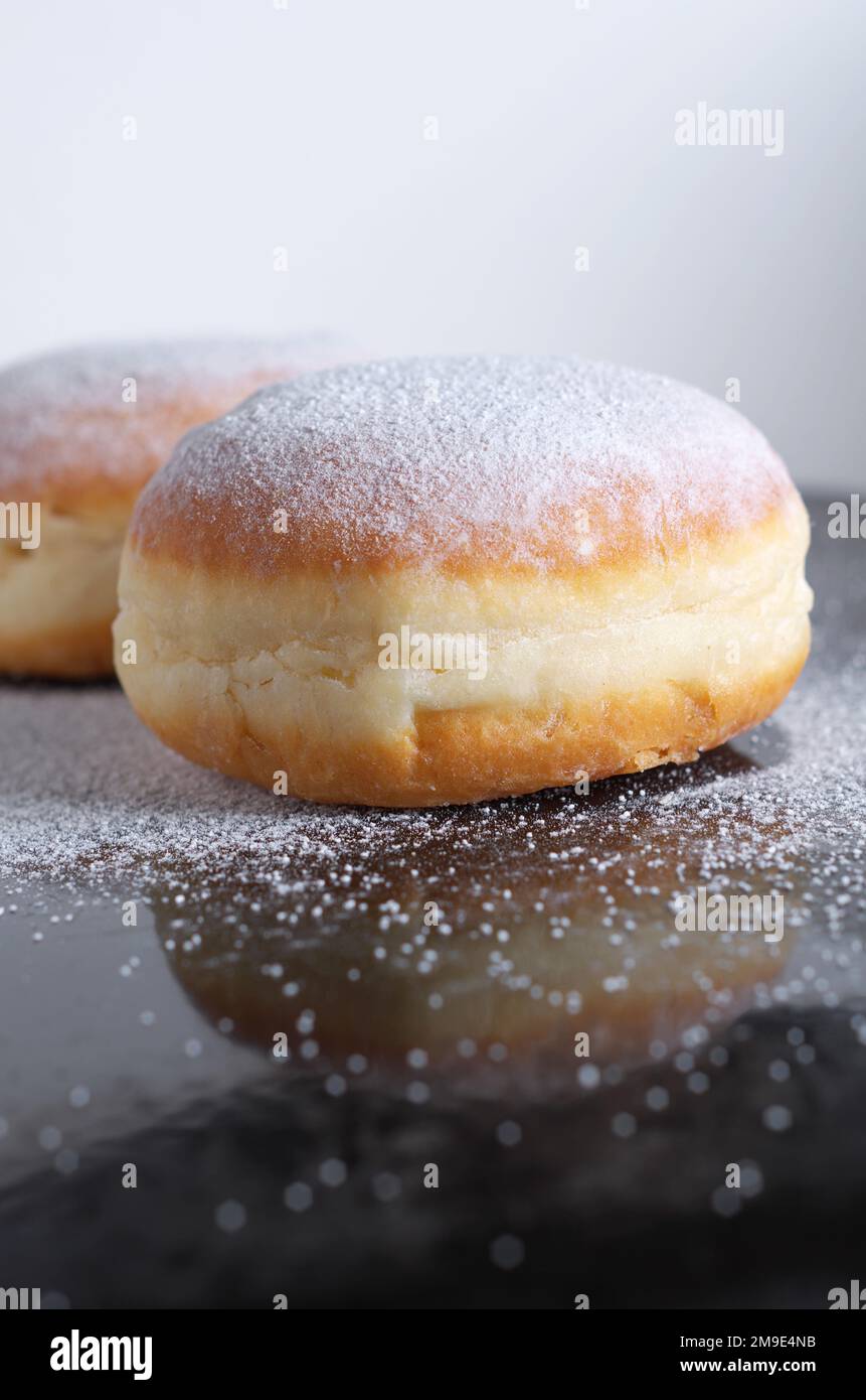 German donuts berliner with powdered sugar on black background close-up ...