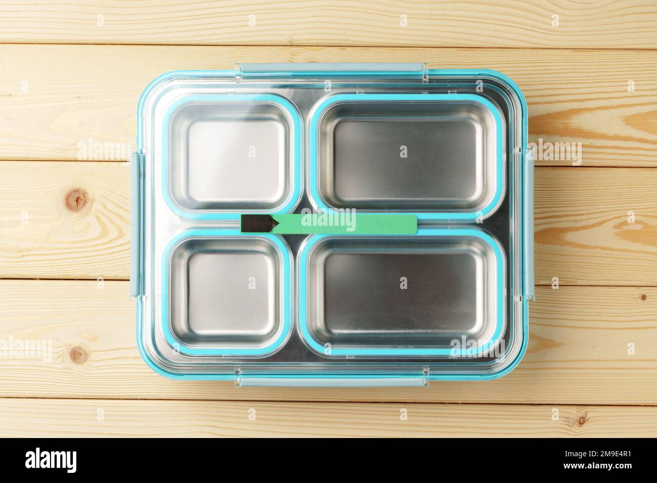 Metal lunch box with compartments on wooden background Stock Photo - Alamy