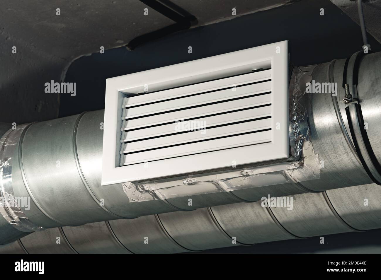 Silver ventilation pipes hanging from the ceiling inside the building ...