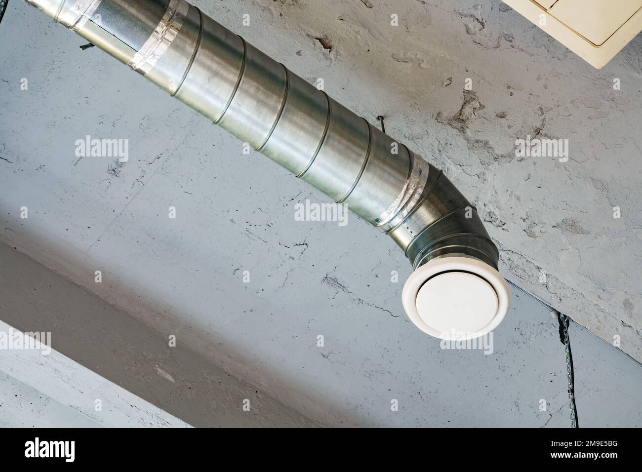 Silver ventilation pipes hanging from the ceiling inside the building ...