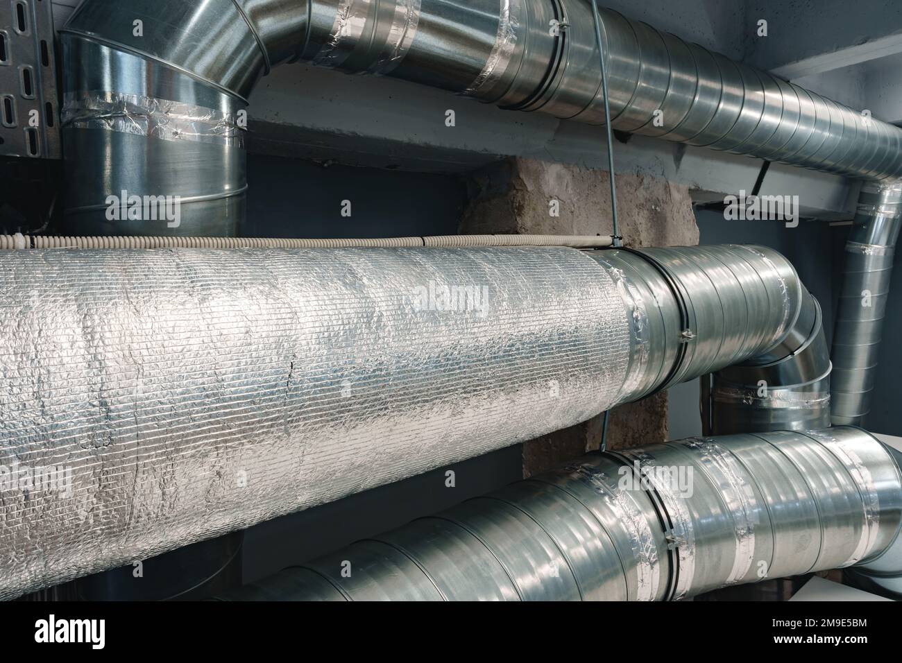 Silver ventilation pipes hanging from the ceiling inside the building ...