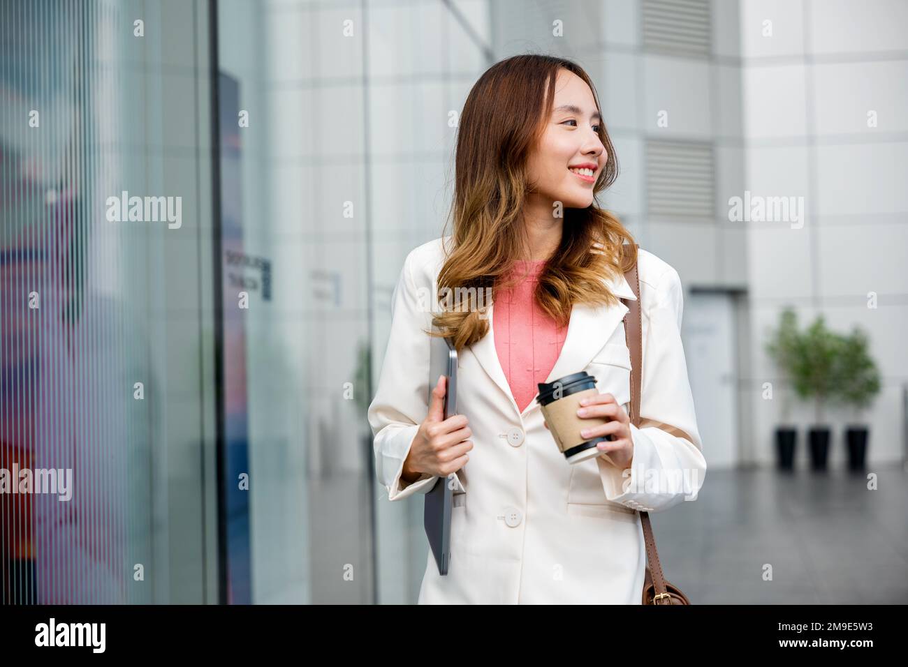 woman wearing white suit jacket and smile while go to work outdoor mirror building Stock Photo ...