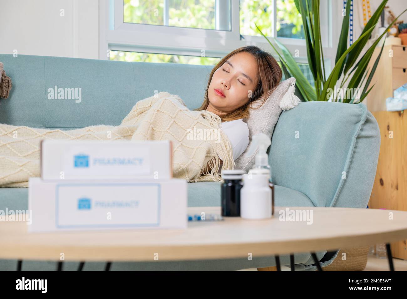 Asian young woman tired sick she sleep and resting on sofa after take ...