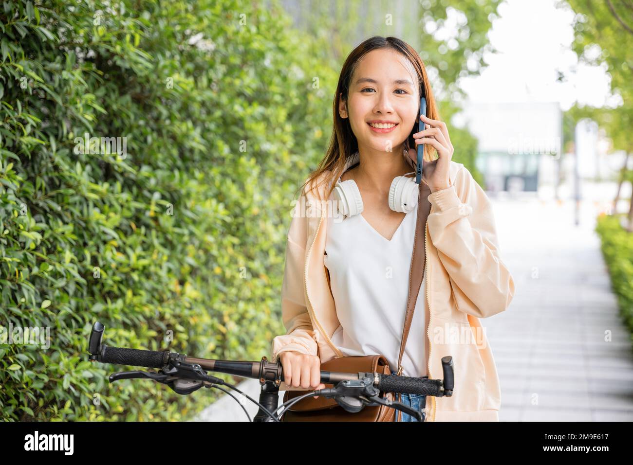 Happy female smiling walk at street with her bike on city road and ...