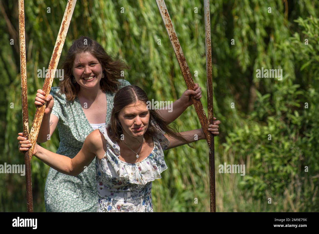 Two young girls swinging, Mecklenburg-Western Pomerania, Germany Stock ...