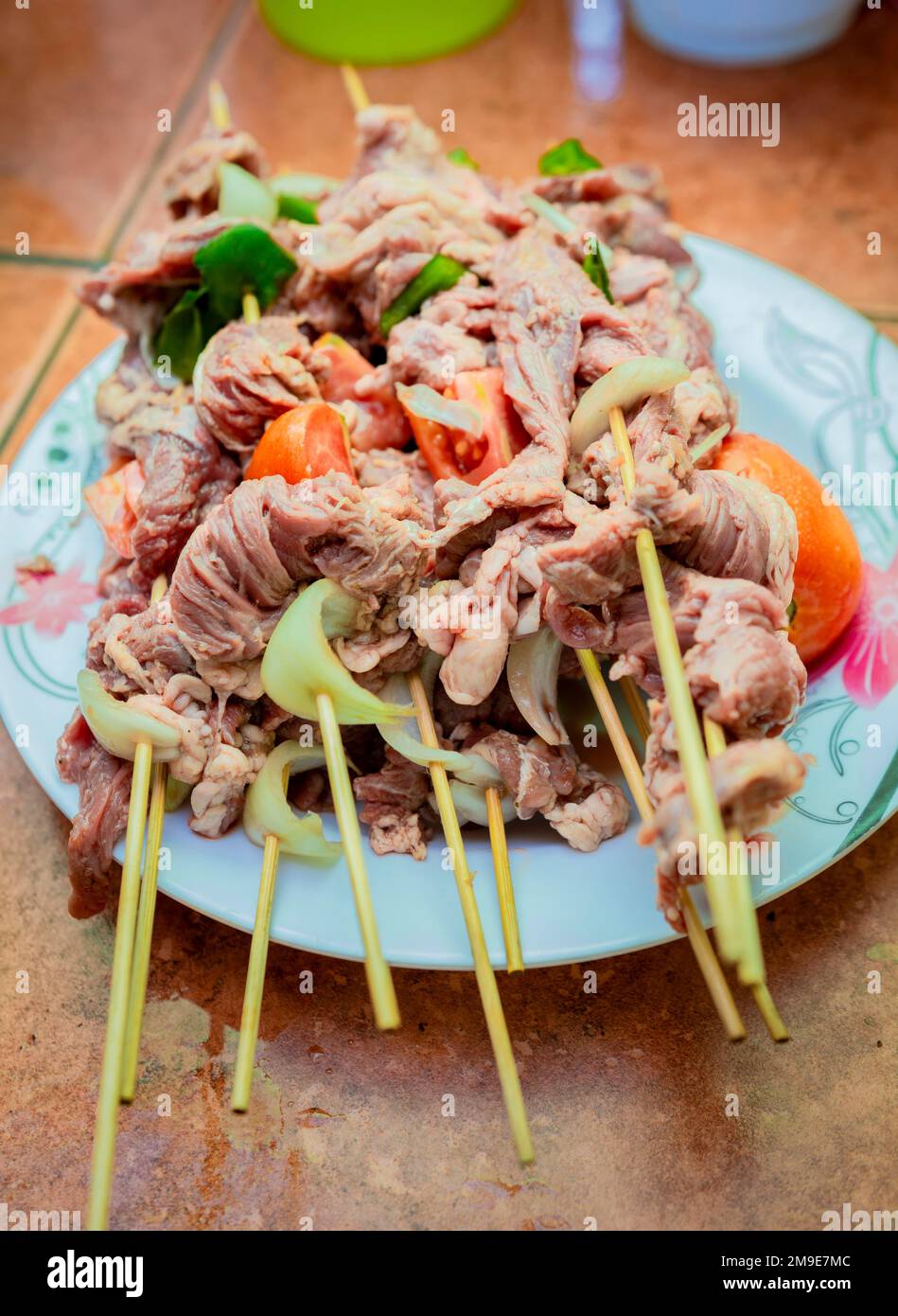 Raw beef skewers on a plate. Close up of raw beef meat skewers with ...