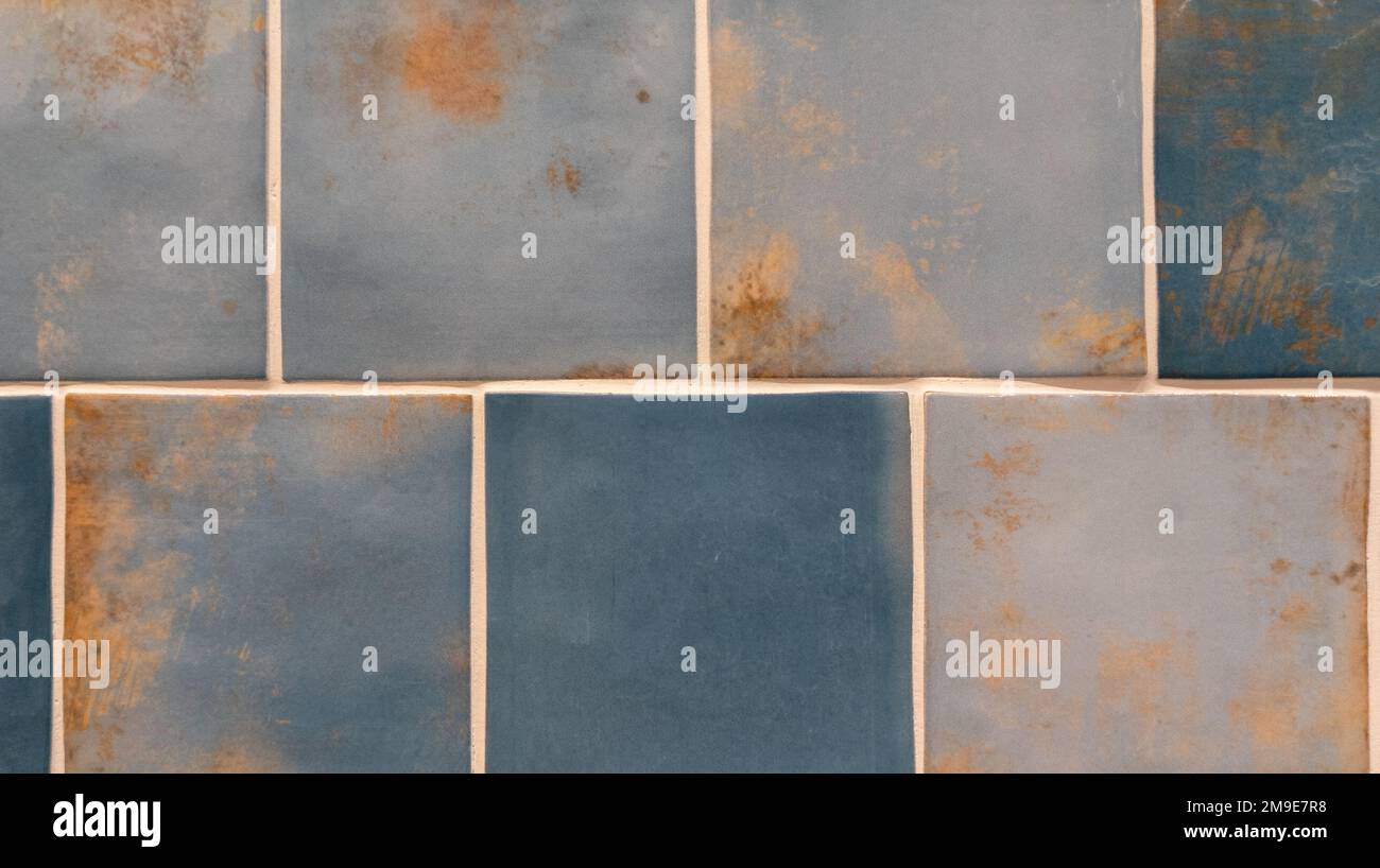 old and worn tiling tile wall background with traces of oxidation blue ...