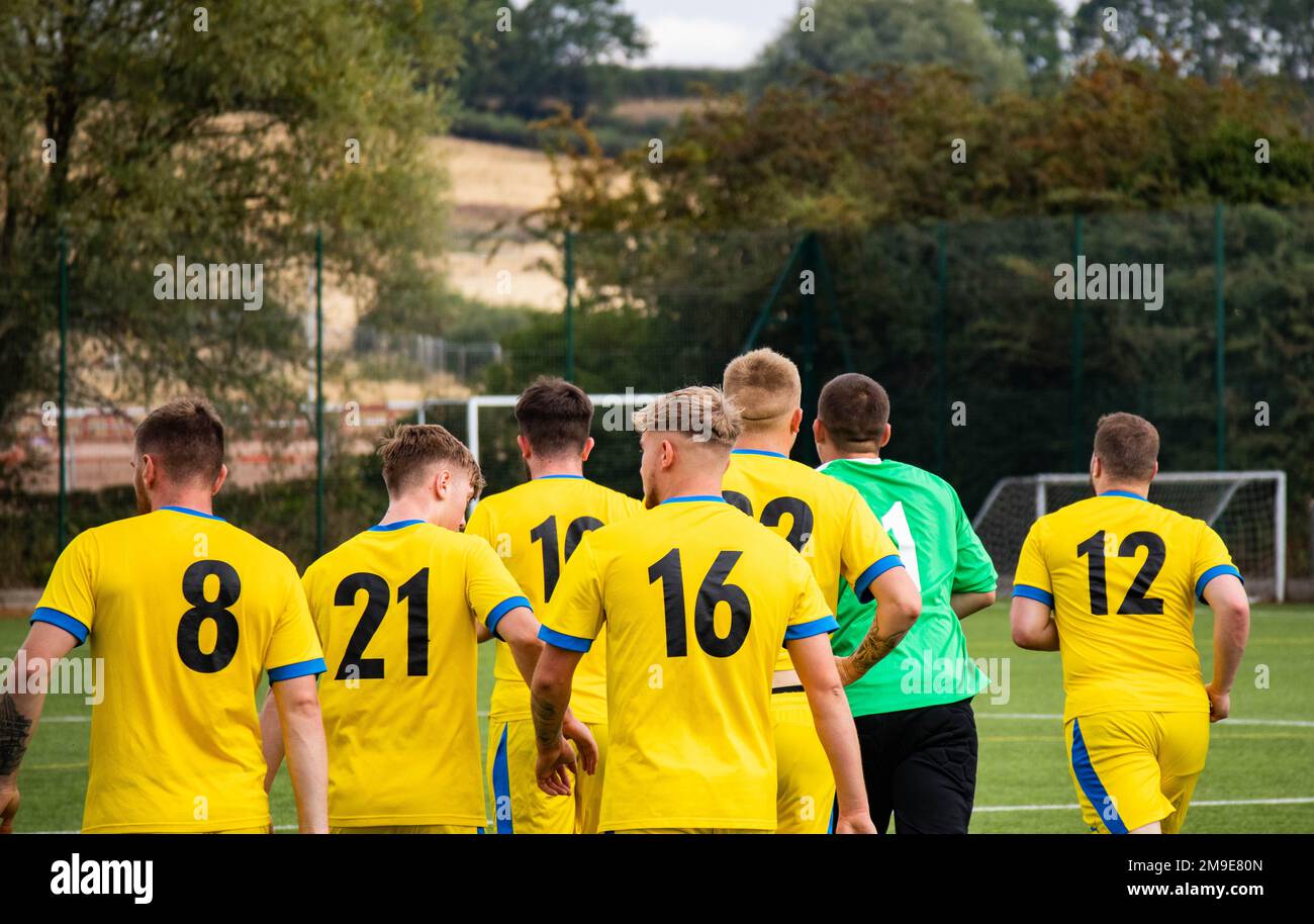 A close-up of a soccer team in yellow kit celebrating after a goal ...