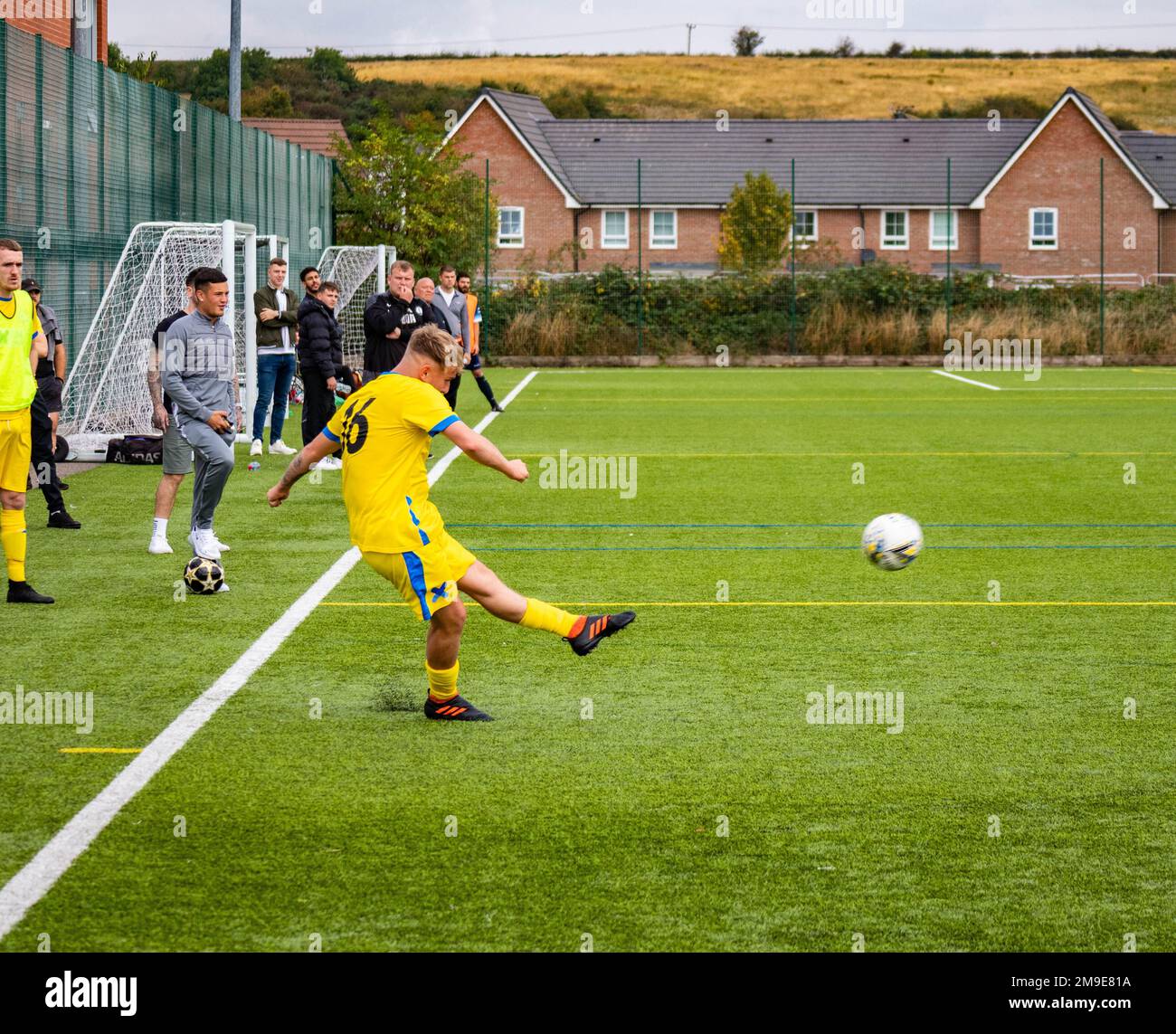 A soccer player in yellow kit taking a free kick during a match Stock ...