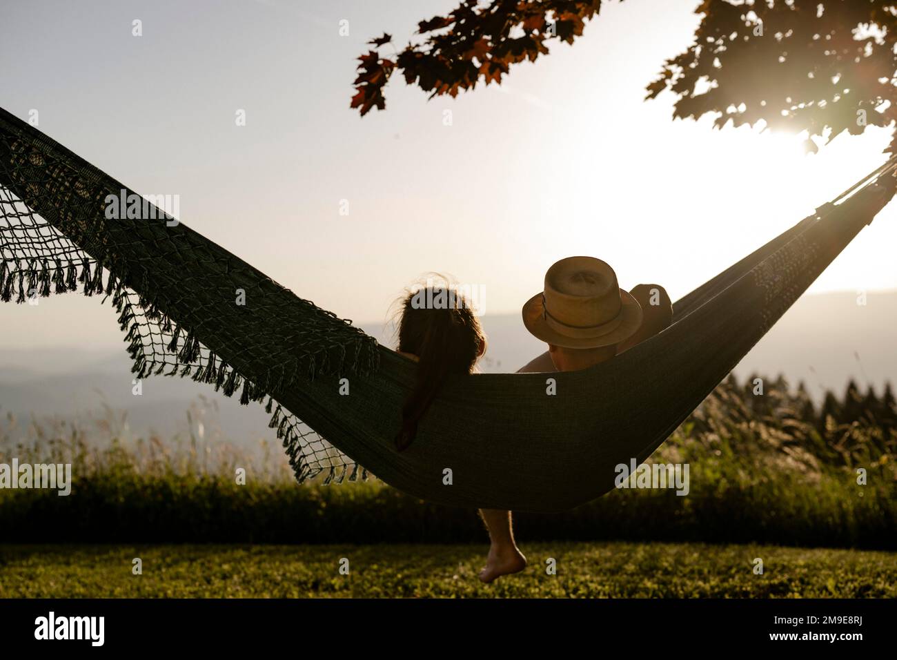 Couple lying in a hammock at sunset, Carinthia, Austria Stock Photo - Alamy
