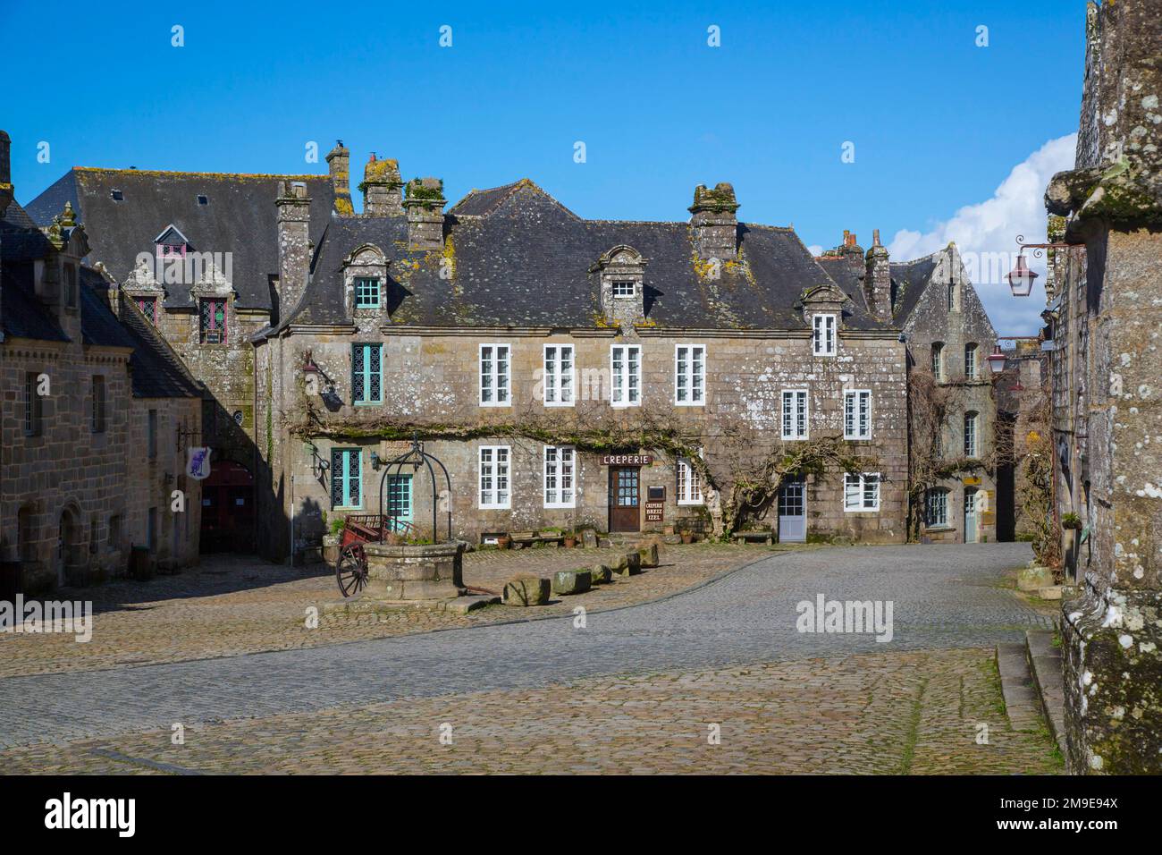 Village square with old horse-drawn cart and fountain, Locronan, named ...
