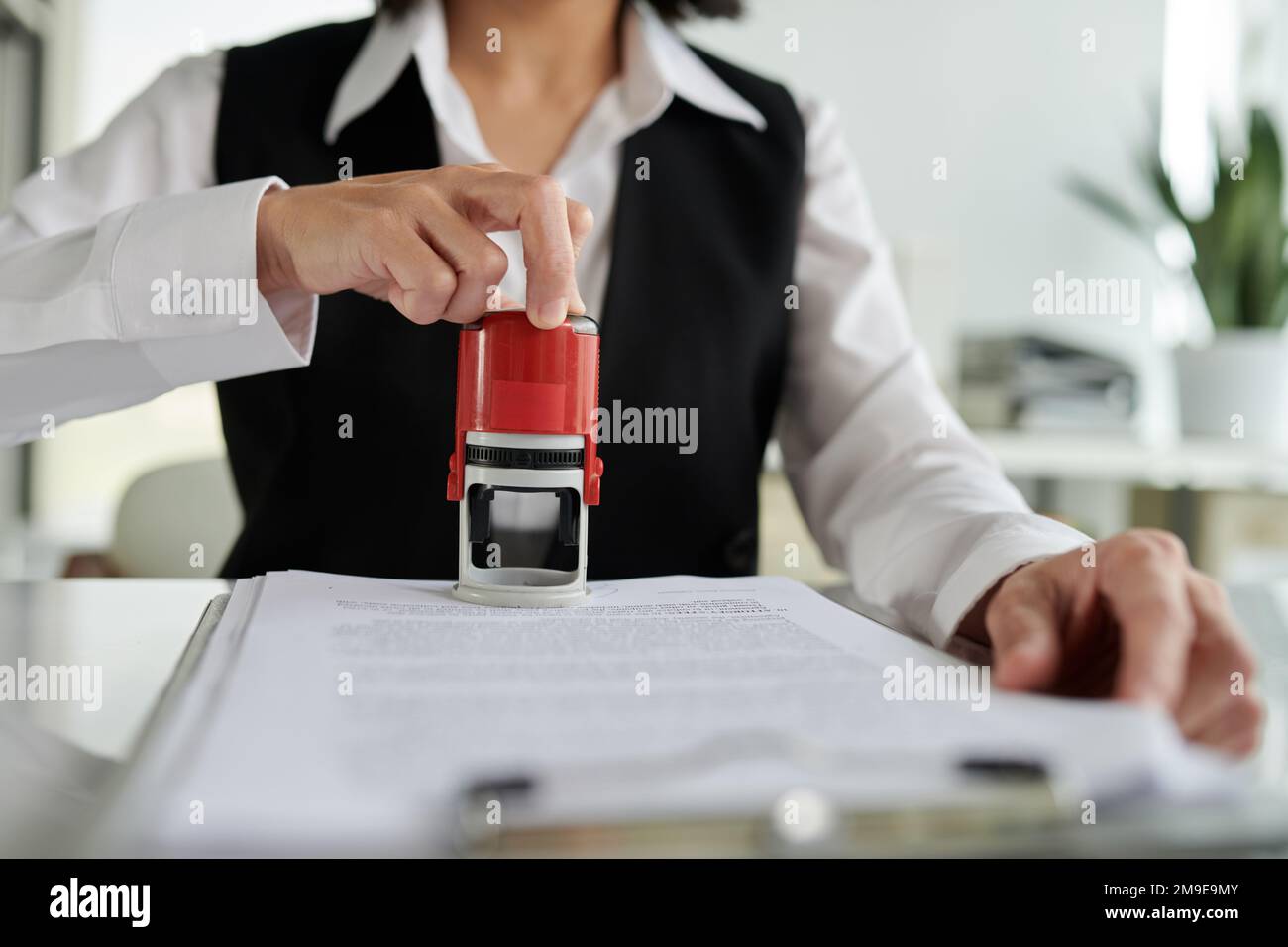 Notary putting seal on document adfter proofreading Stock Photo - Alamy