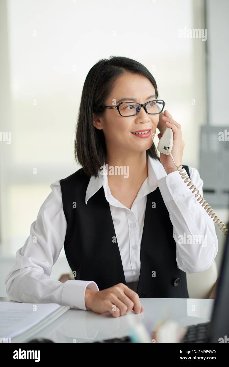 Portrait of positive social worker answering phone call Stock Photo - Alamy