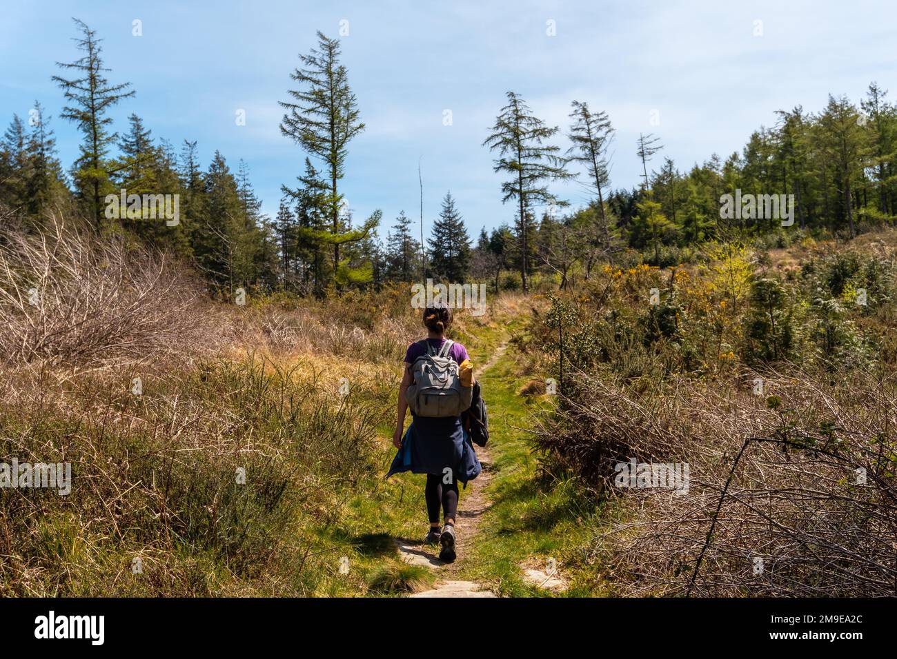A young woman walking on top of Mount Andatza in the town of Usurbil ...