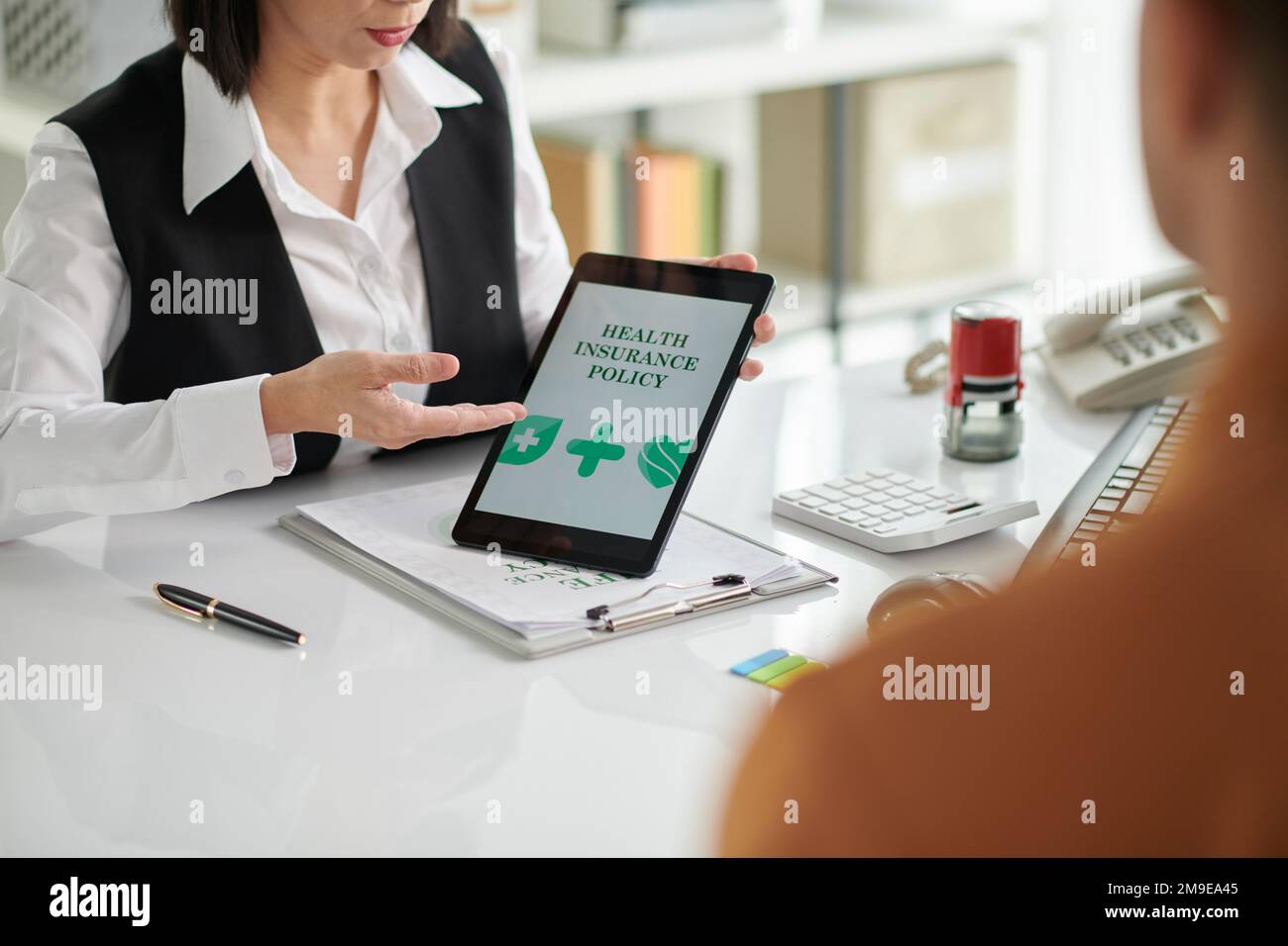 Agent explaining advantages of having health insurance policy to client ...