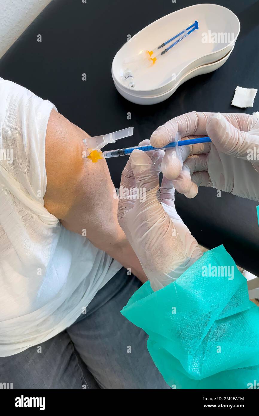 Elderly woman receives injection with medical syringe fourth ...