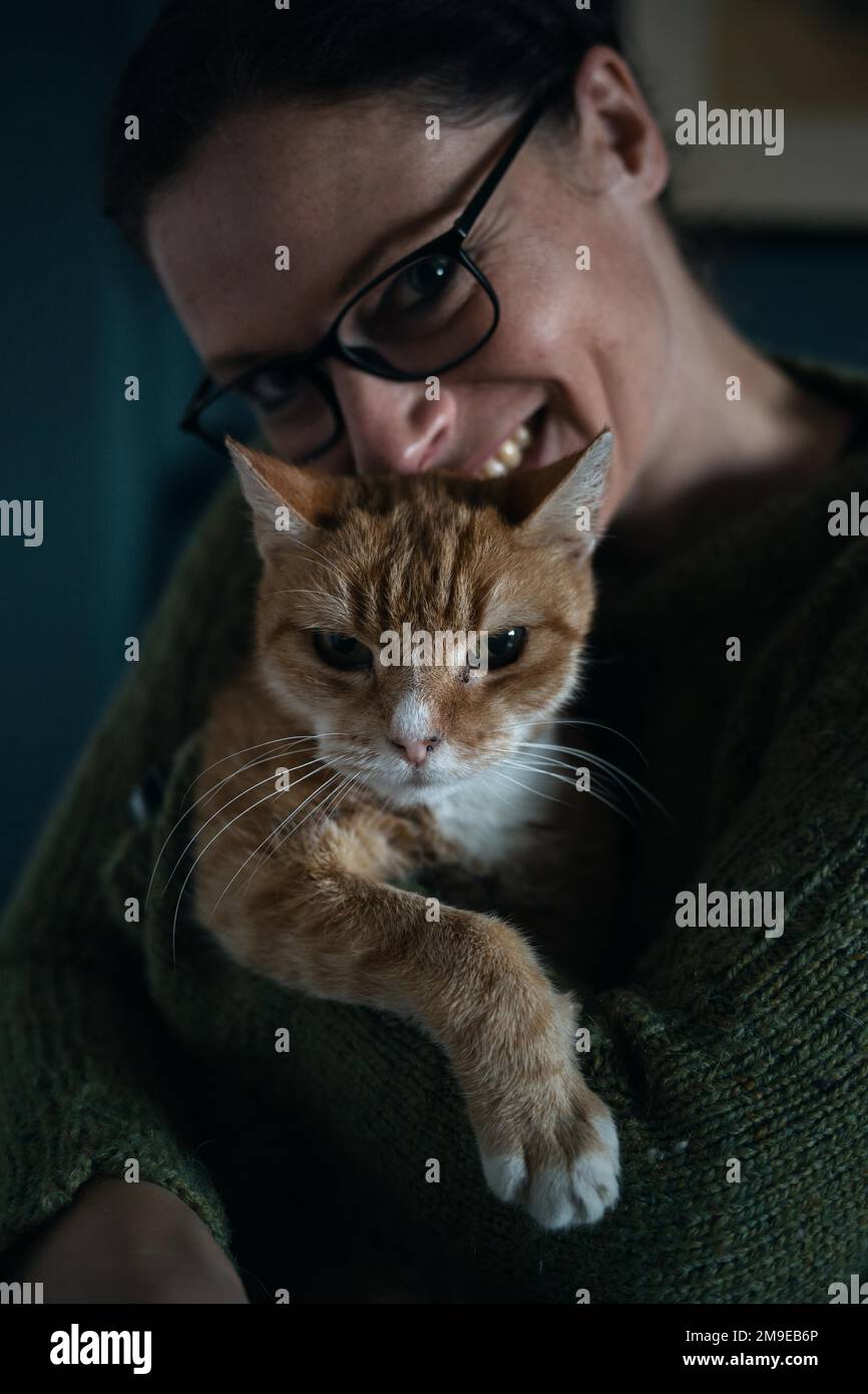 Portrait of a woman holding a cat, interior view Stock Photo - Alamy