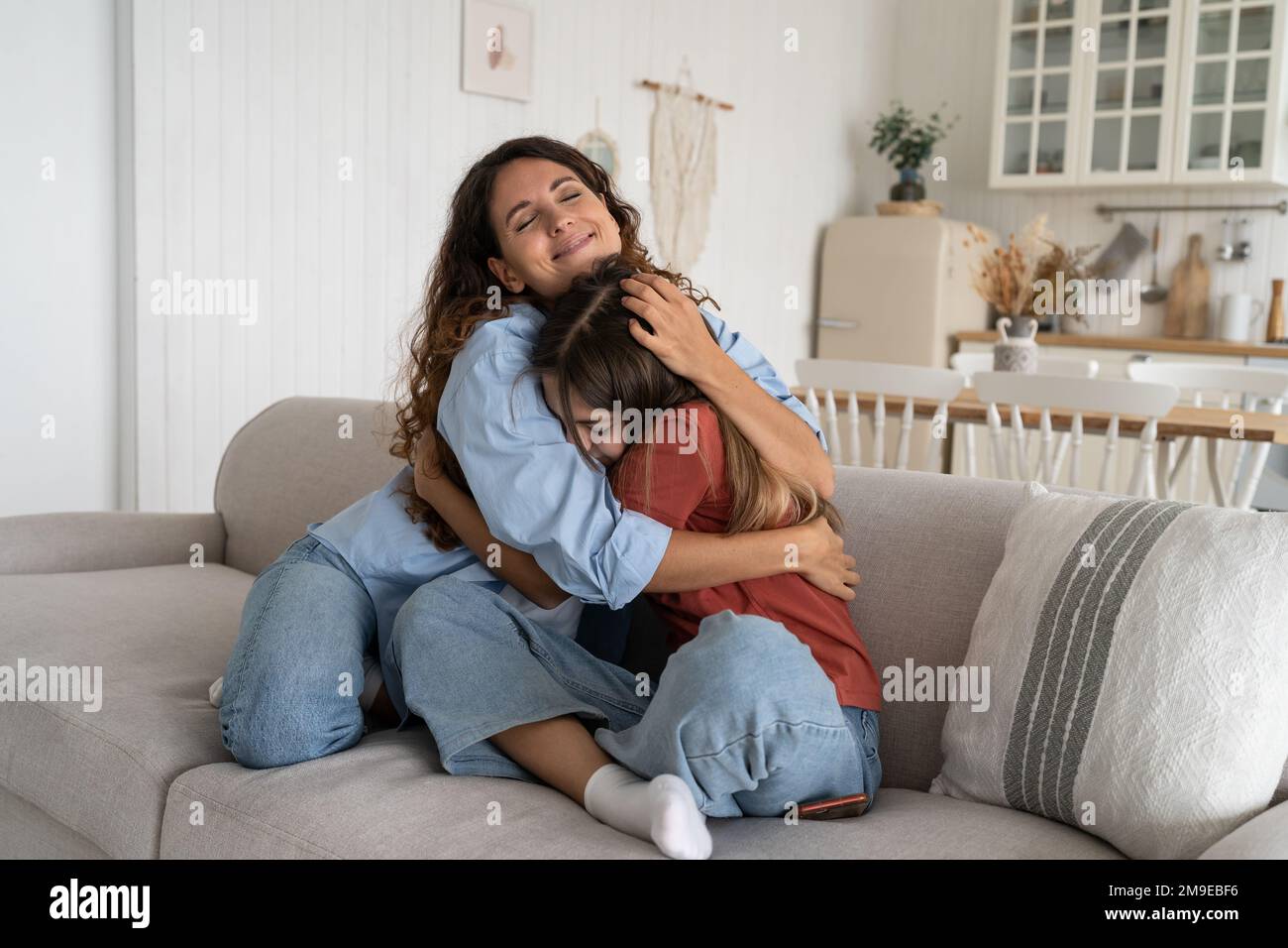 Smiling supportive young mother hugging cuddling teen daughter, mom ...