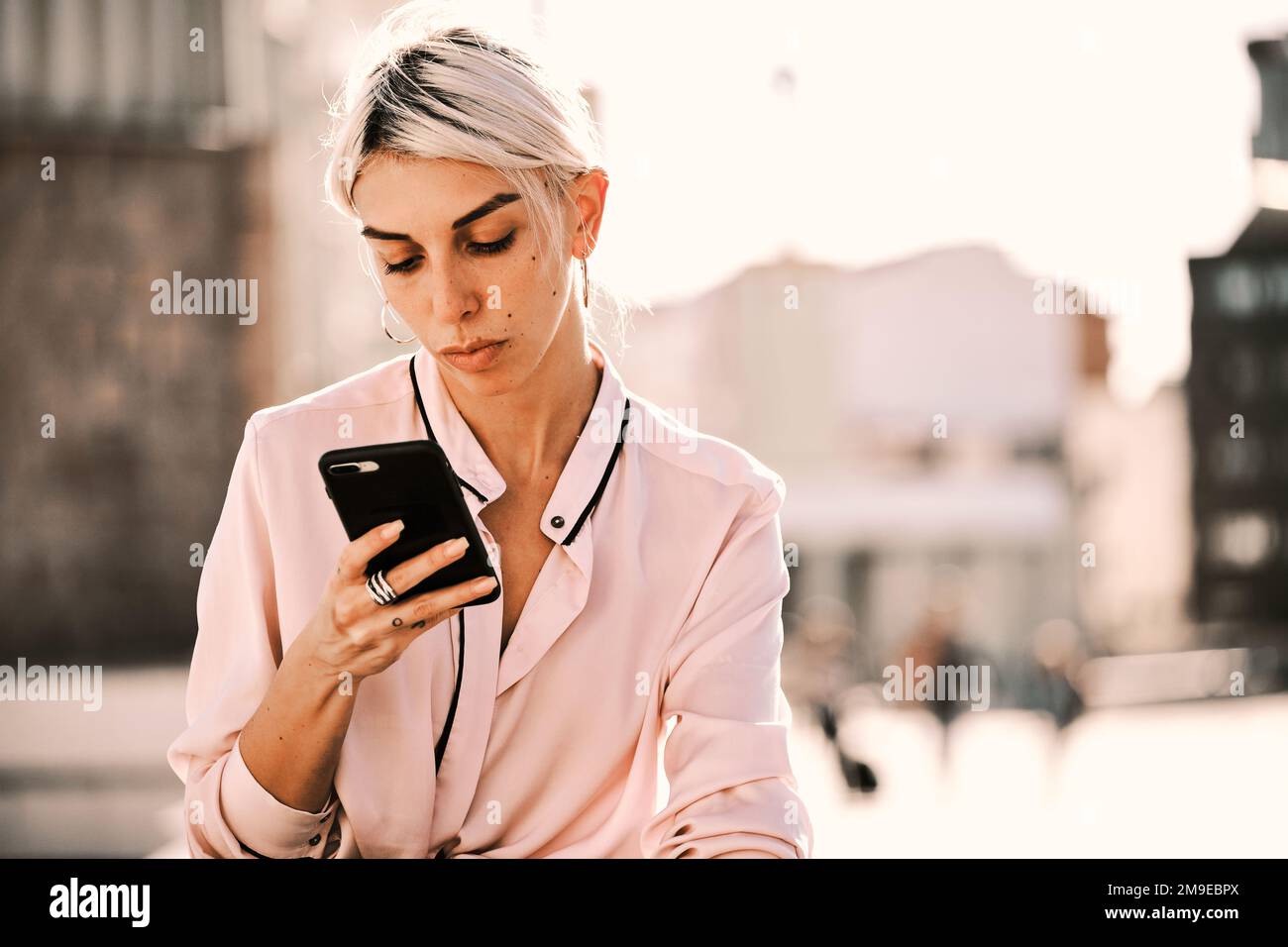 Stylish woman using her mobile phone outdoors Stock Photo - Alamy