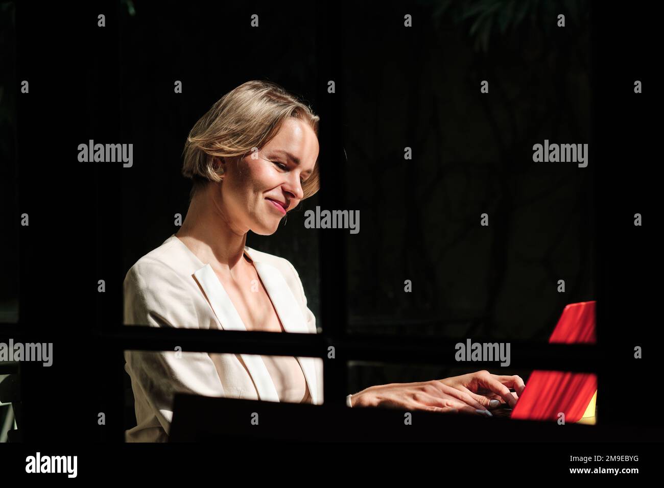Businesswoman using a laptop while illuminated by the sunlight Stock ...