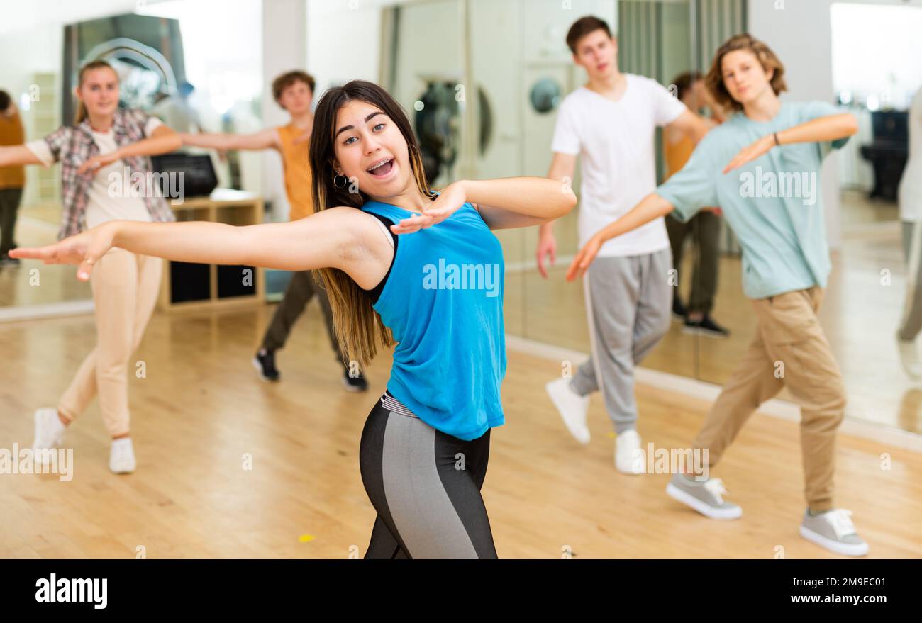 Cheerful emotional teen girl training dance movements in choreography class Stock Photo - Alamy