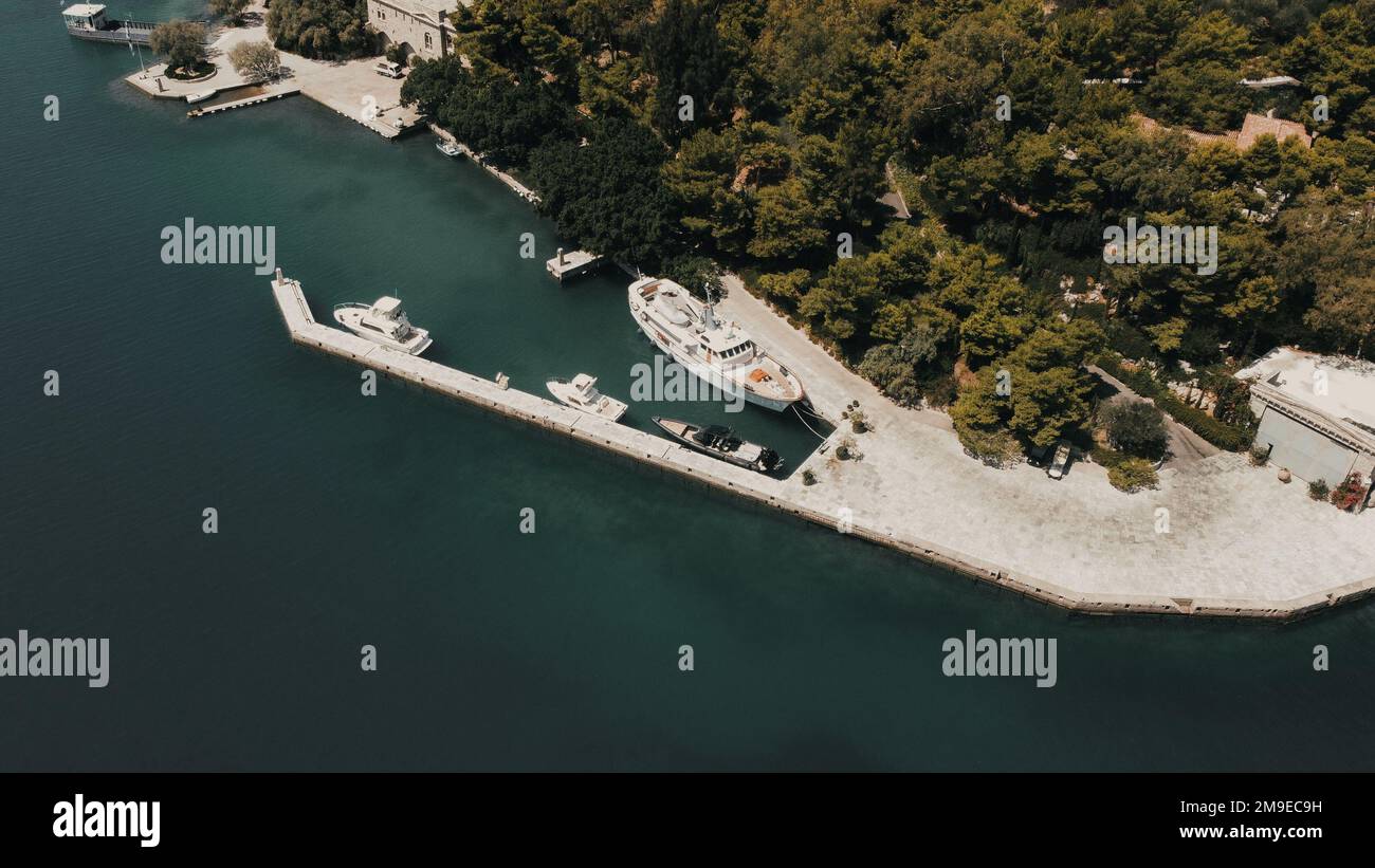 A bird's eye view of a ship moored at a harbor of a green island Stock ...