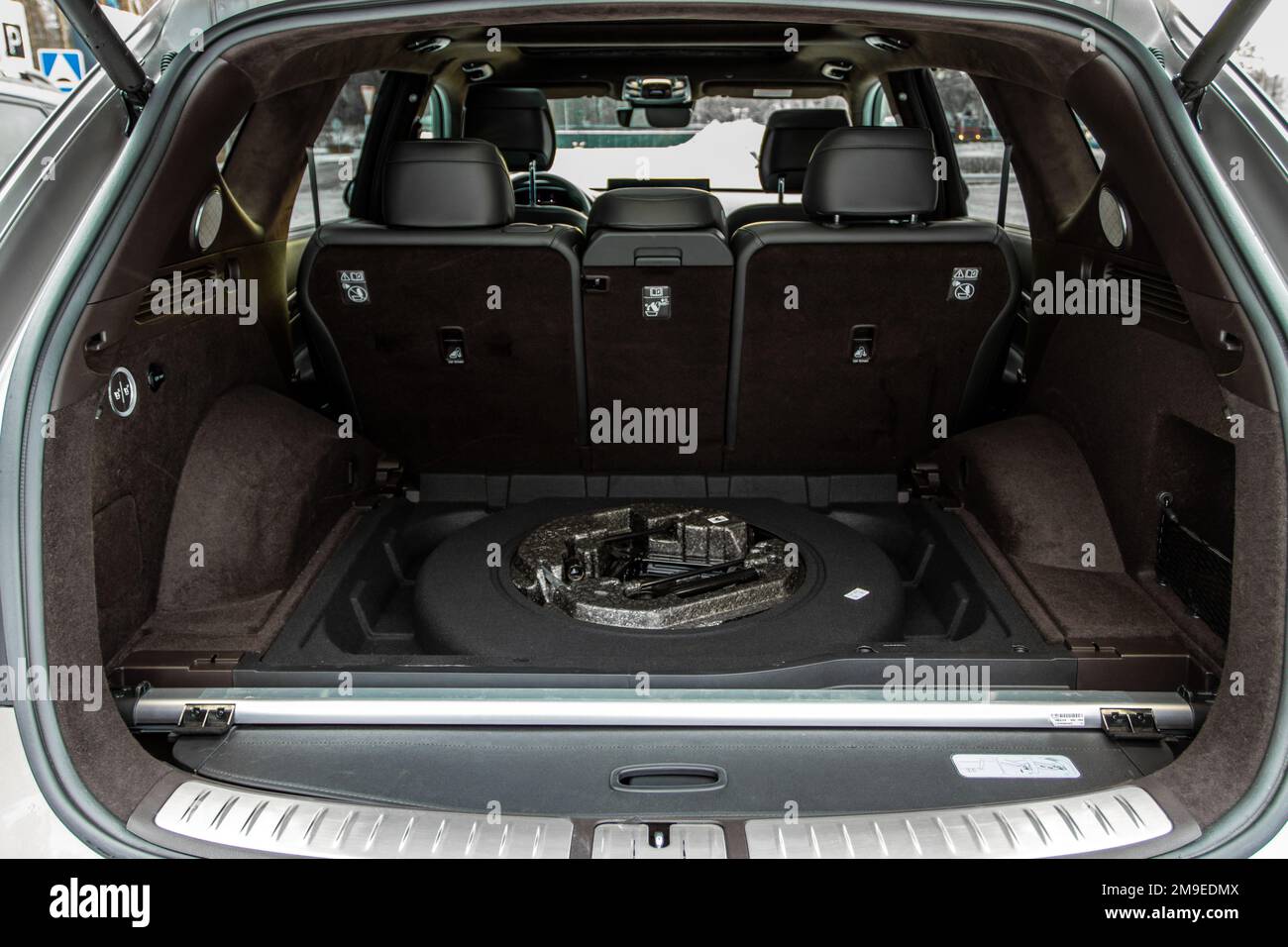 Spare wheel in the trunk of a modern car. Jack lifting and a spare tire ...